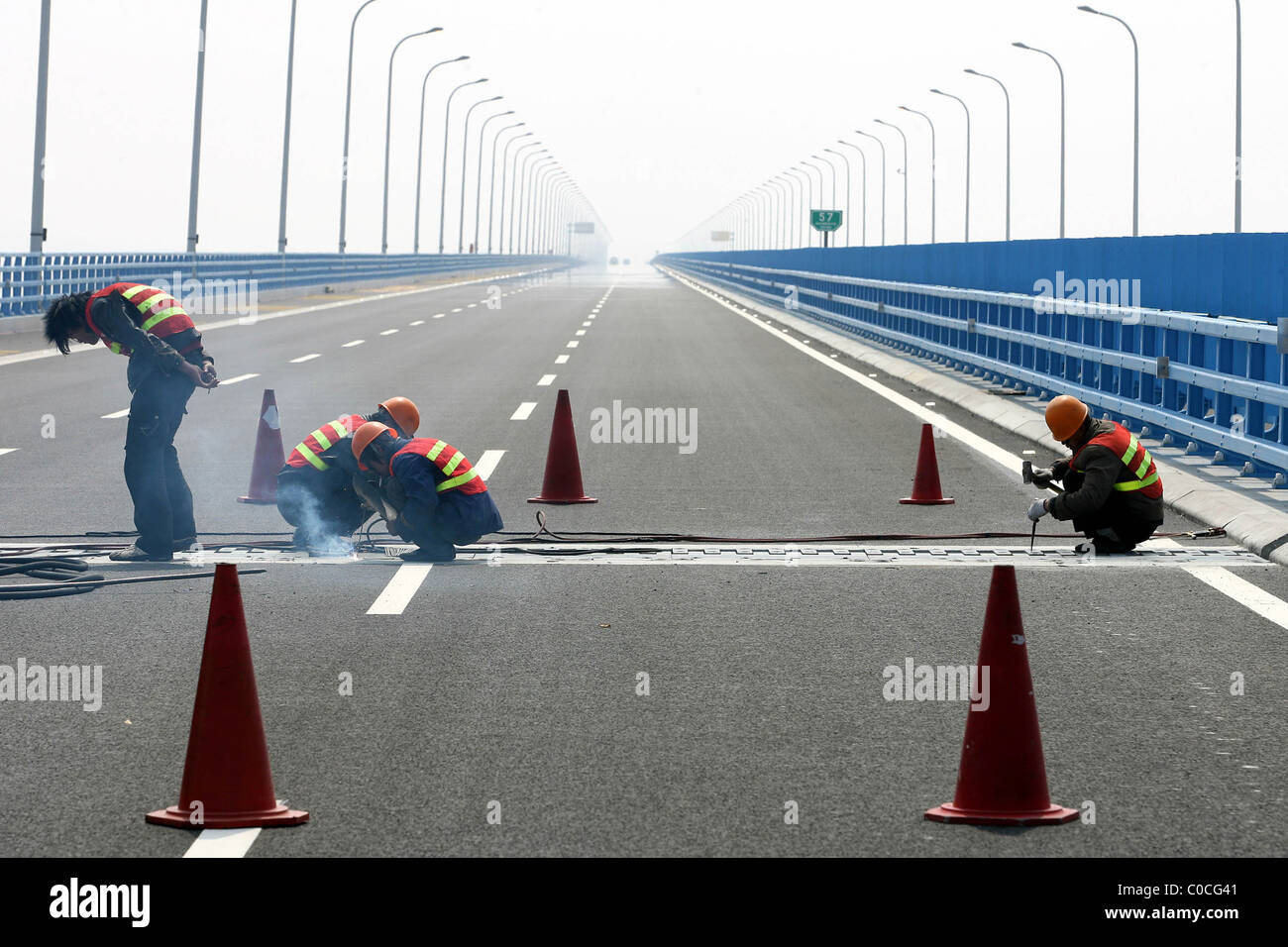 WORLD'S BIGGEST BRIDGE NEARS COMPLETION Workers put the finishing ...