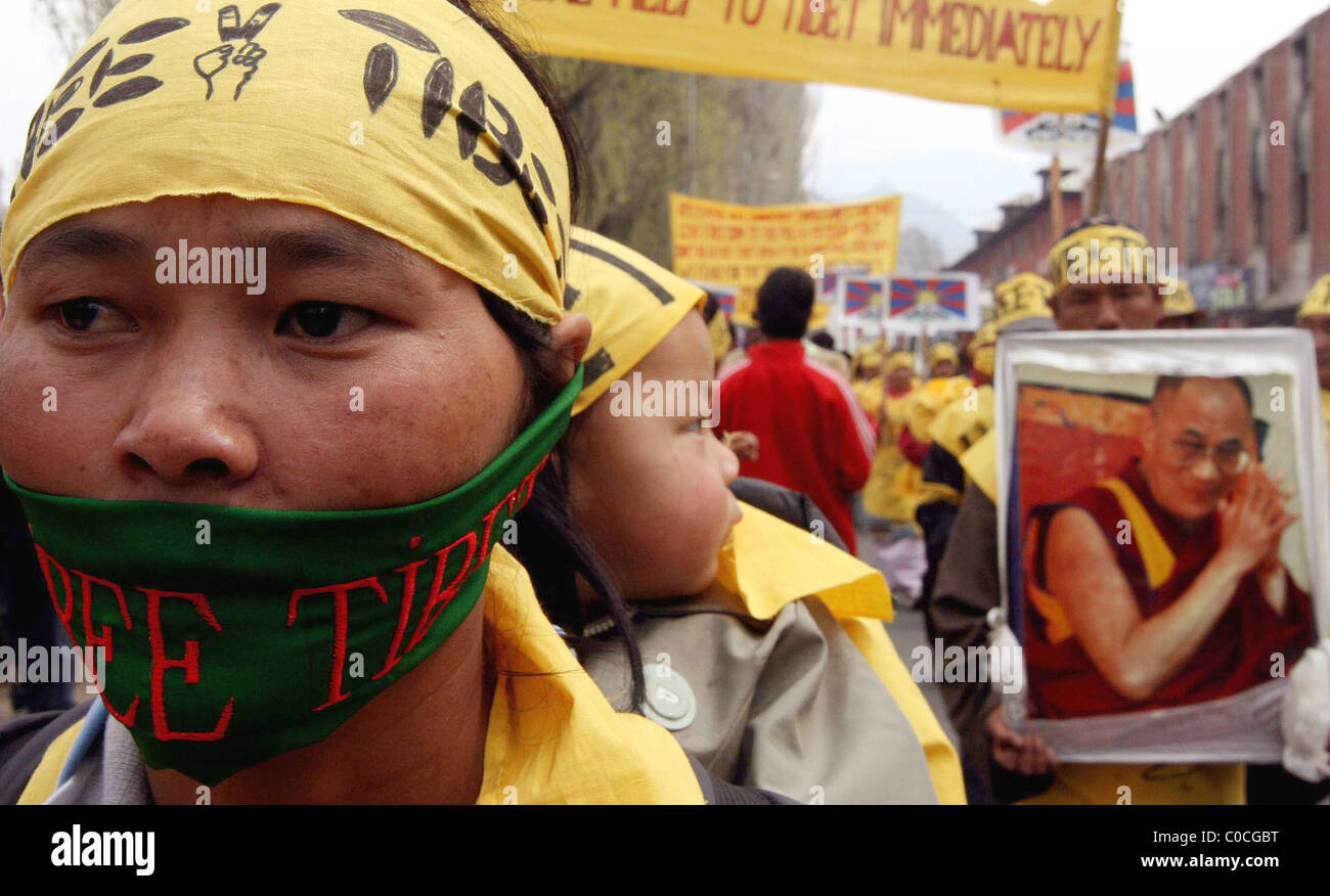 Tibetan exiles wear masks and hold pictures of the Dalai Lama as they ...