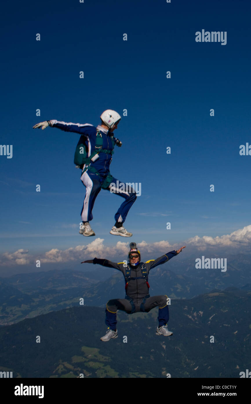 Skydivers flying in sit position around each other and having fun ...