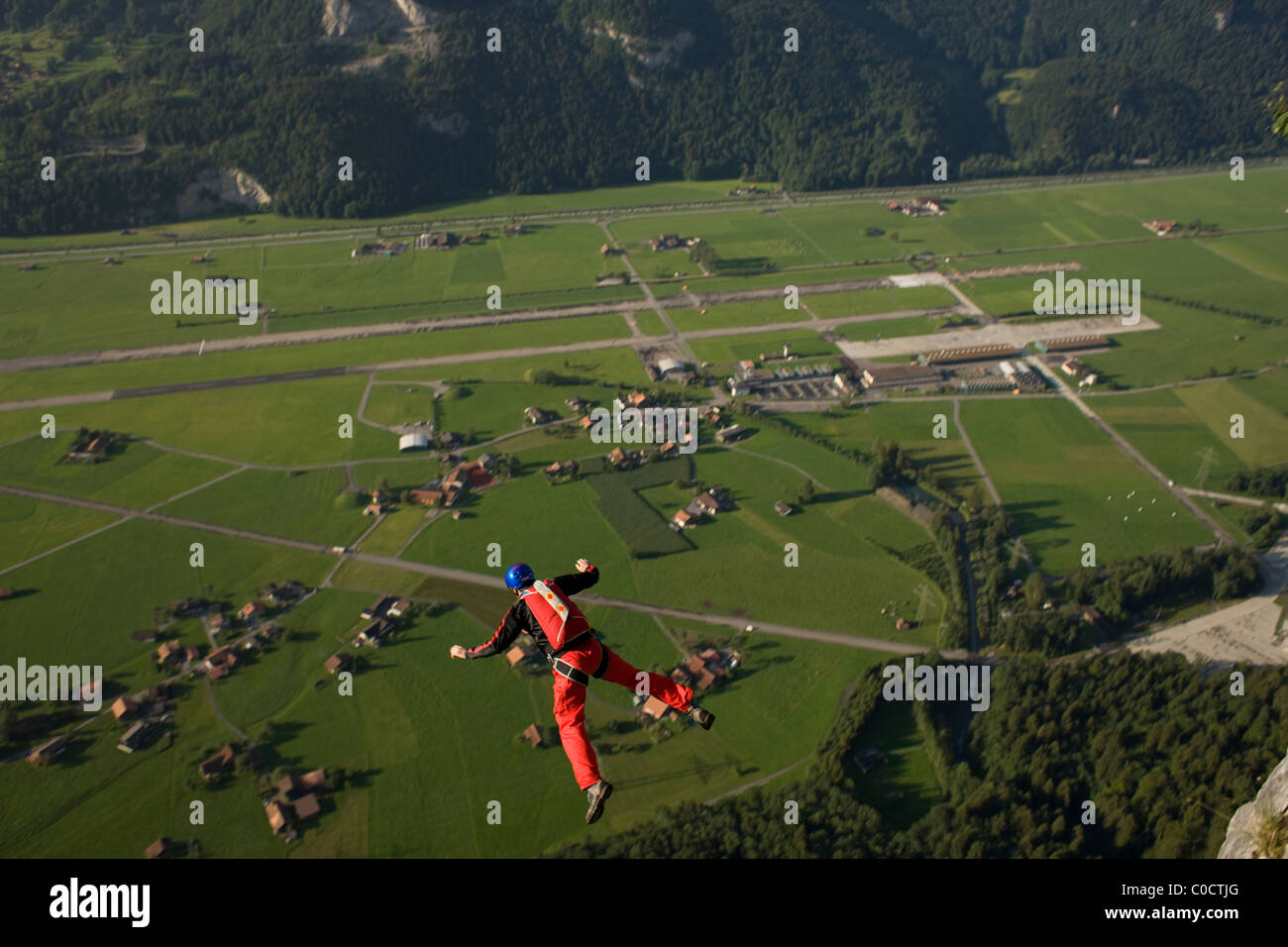 Man is jumping of a cliff and falling down the valley. He is stable in ...