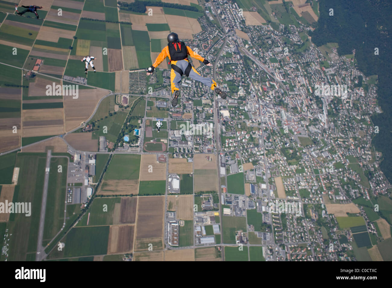 Skydiver is flying in tracking position over small town in free fall ...