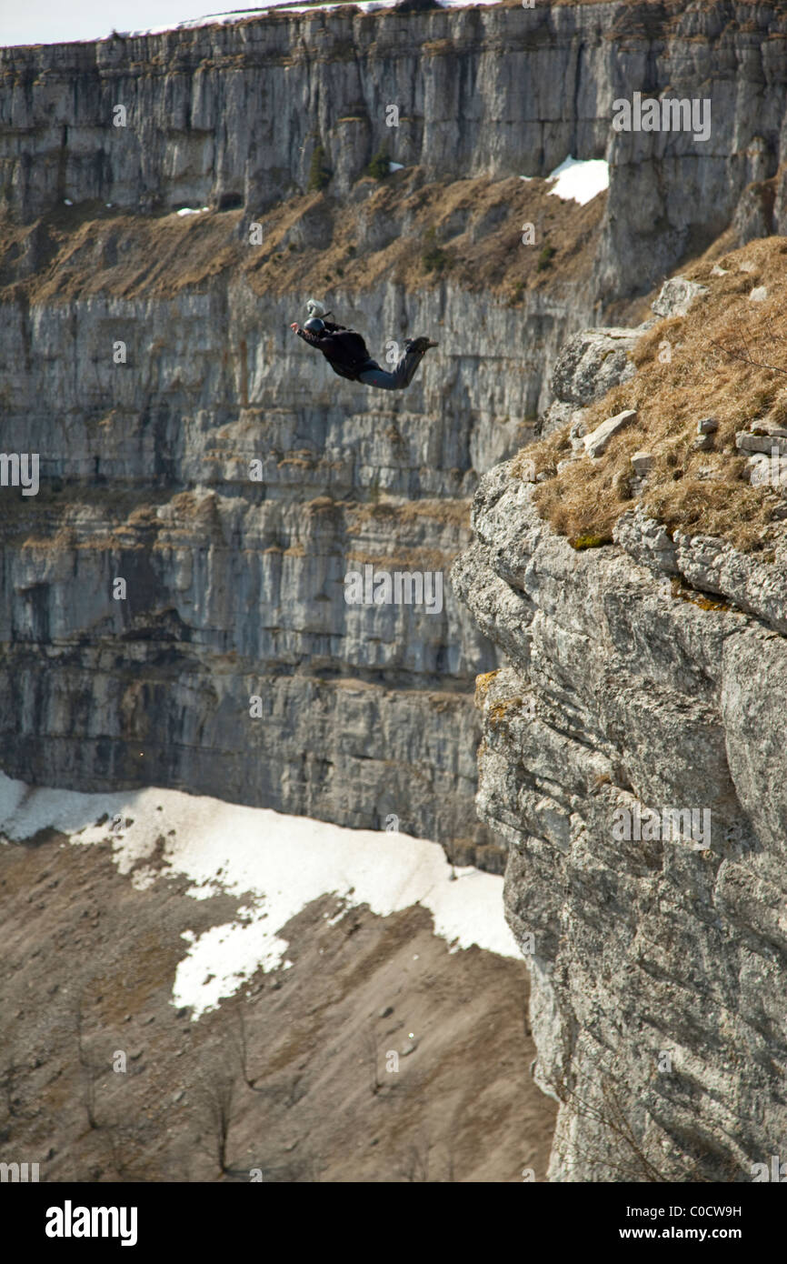 BASE jumper is diving from a cliff into the valley Stock Photo - Alamy