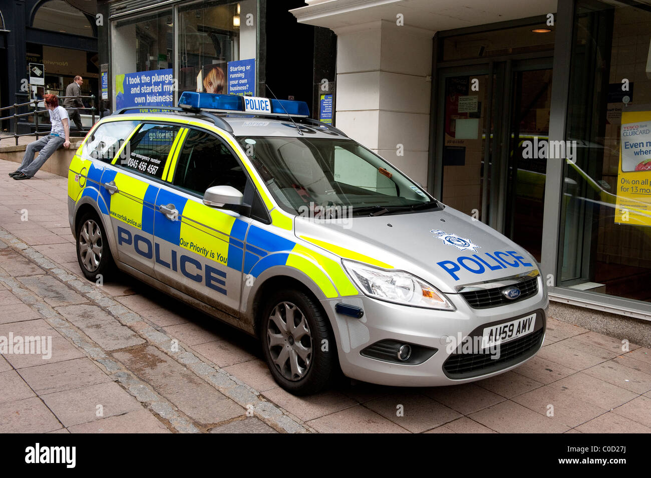 Silver police car parked outside shops on a street in Norwich, Norfolk ...