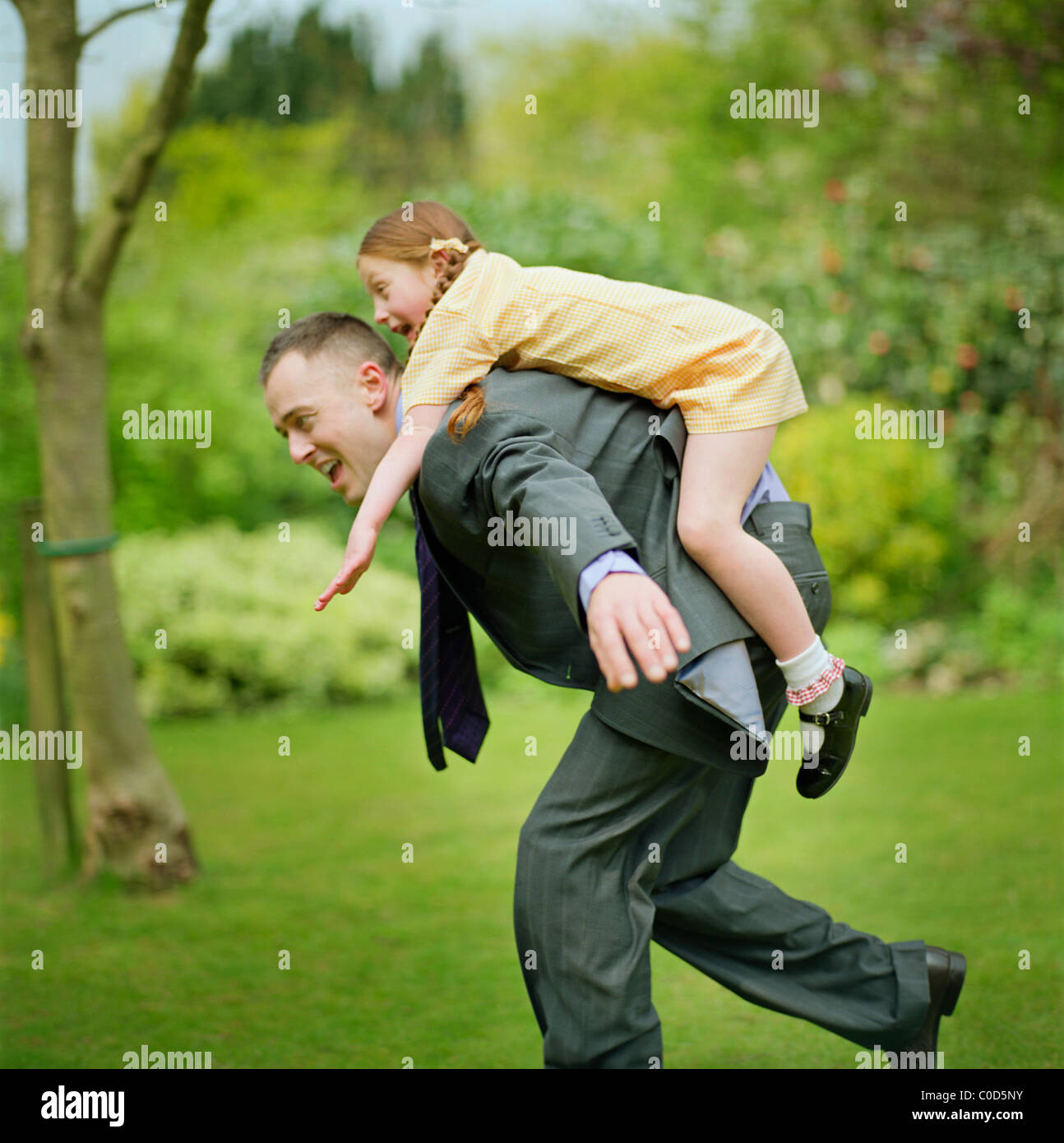 Father giving daughter piggy back Stock Photo - Alamy
