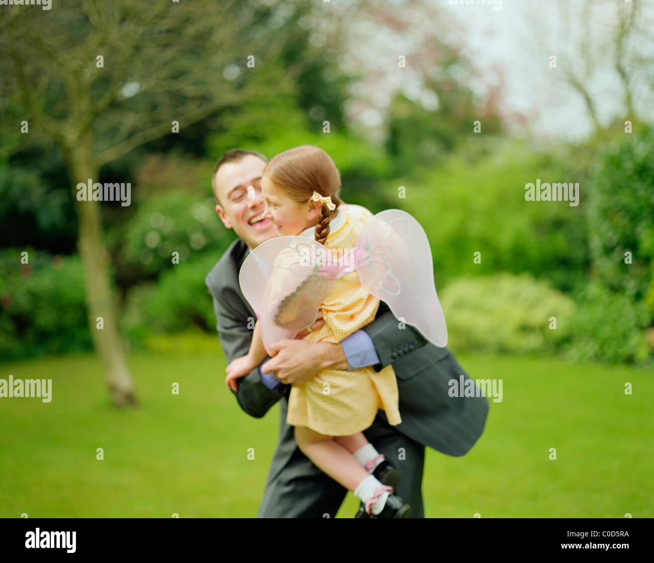 Father holding daughter wearing fairy wings Stock Photo - Alamy