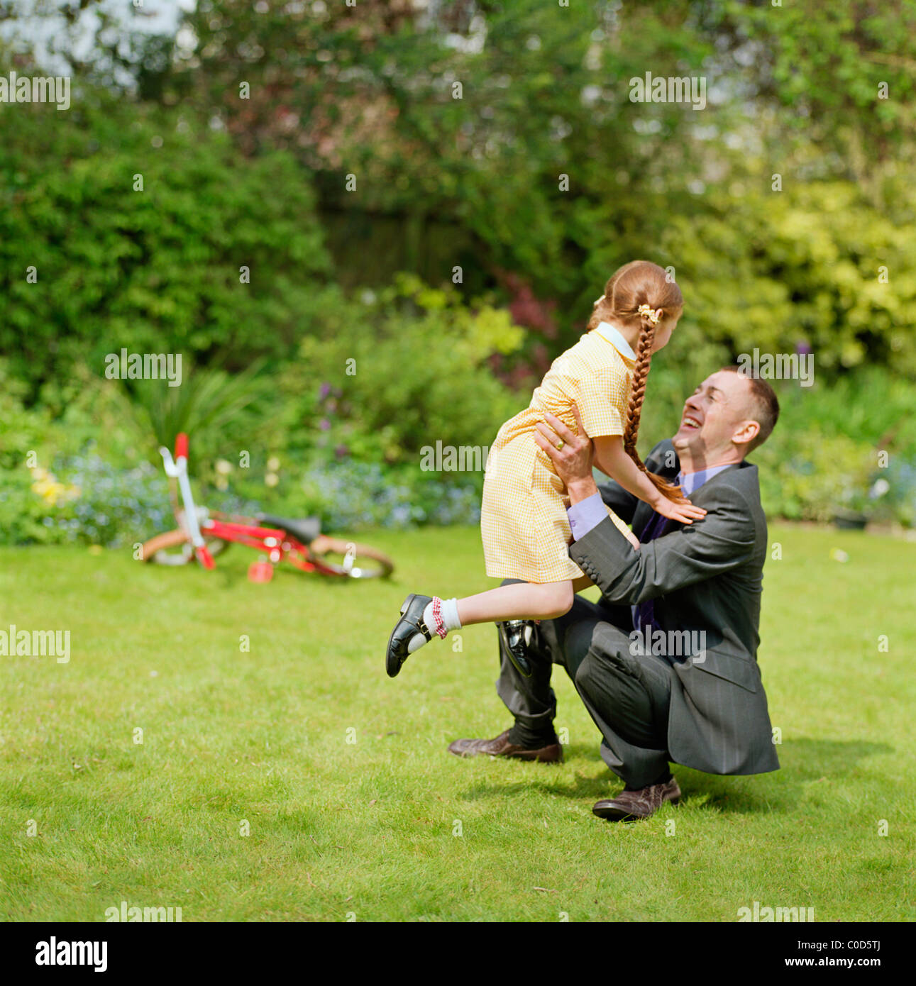 Father lifting daughter in garden Stock Photo - Alamy