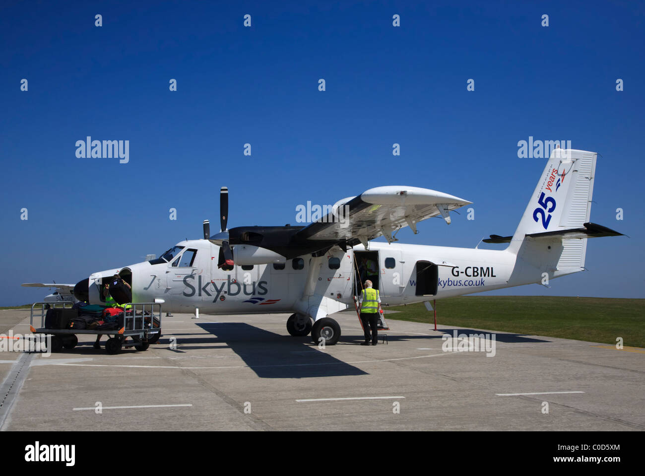 Offloading luggage from a Skybus Twin Otter at St.Mary's airport Isles ...
