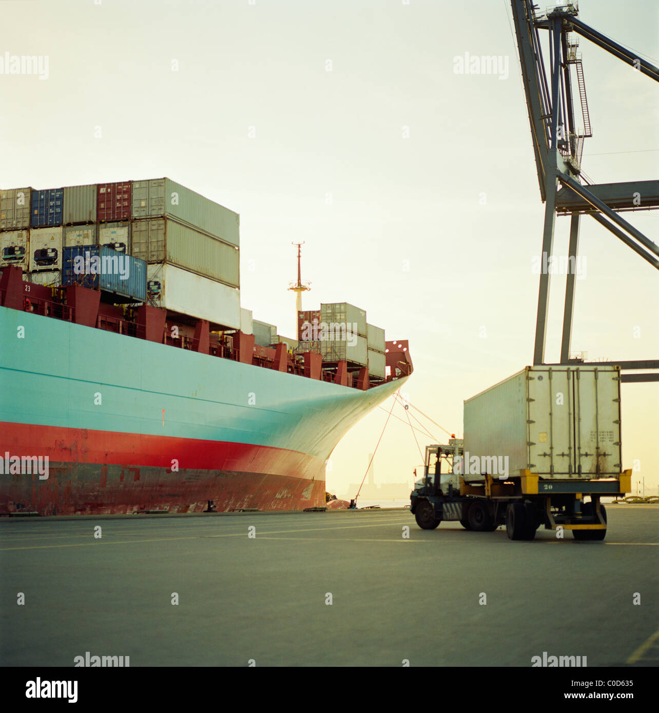 A ship at the quayside with a truck bringing a container to load Stock ...