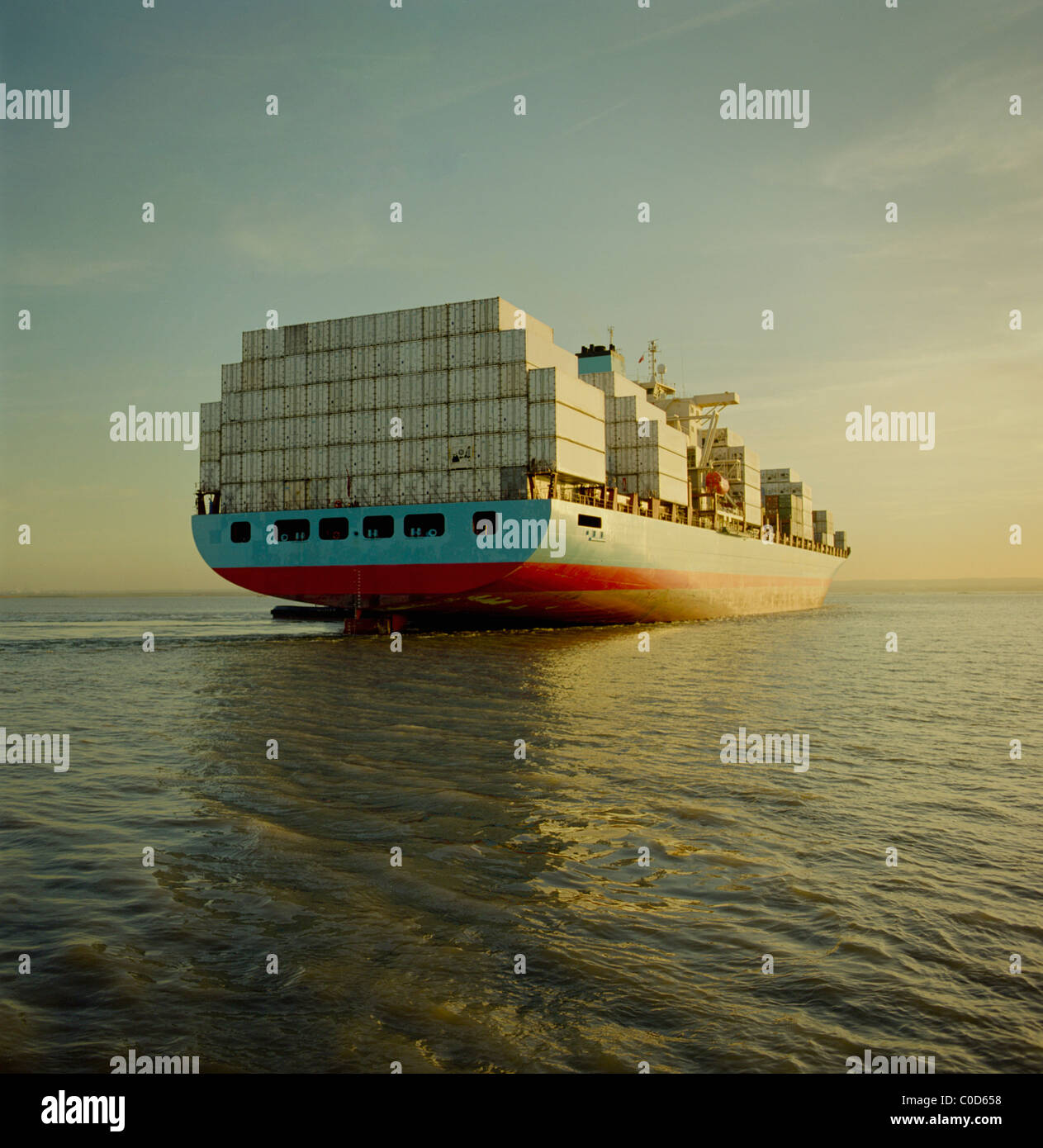 A container ship fully loaded heading out to sea Stock Photo - Alamy