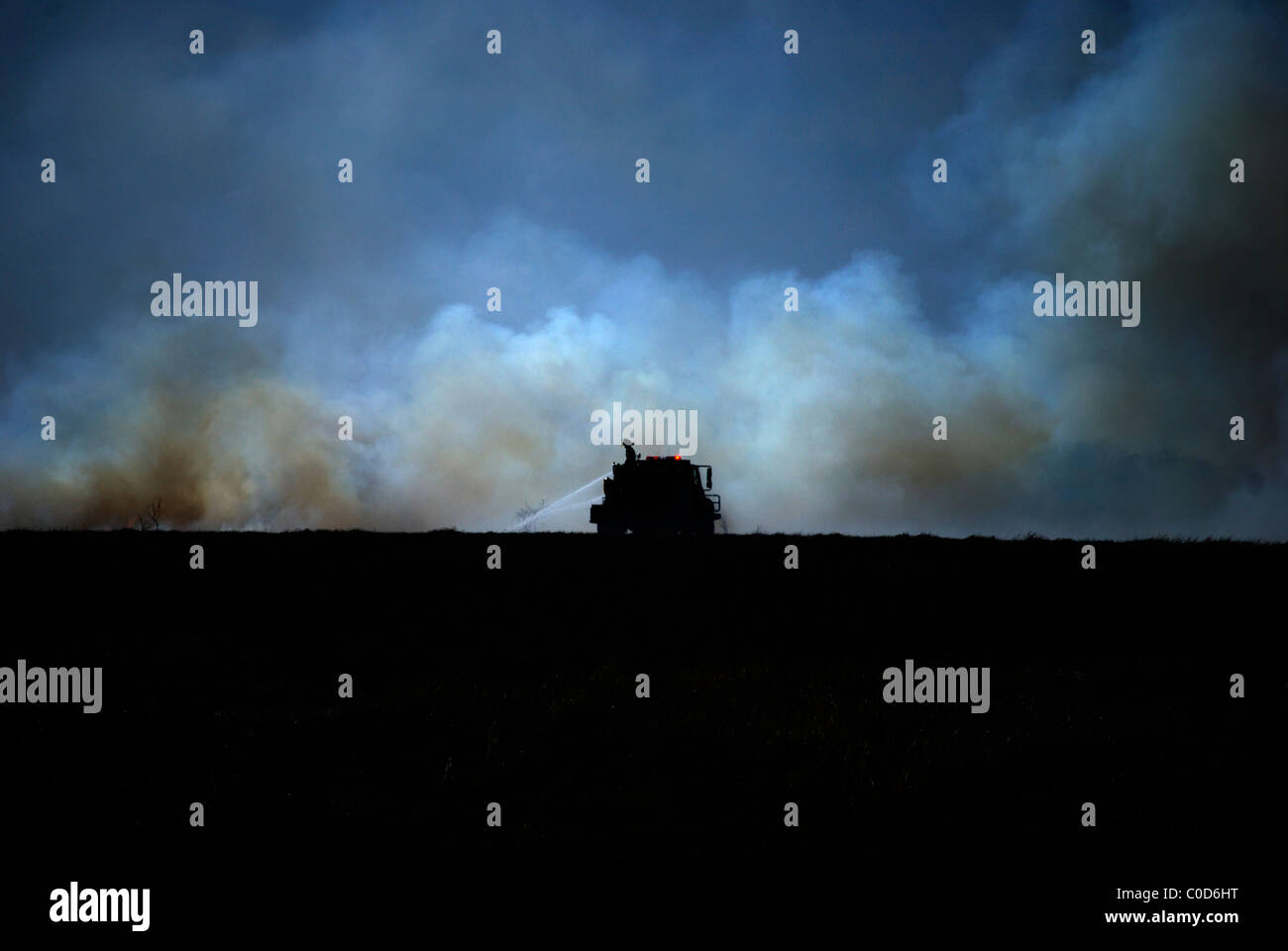 Firemen and fire truck fight large grass fire on Texas prairie, high ...