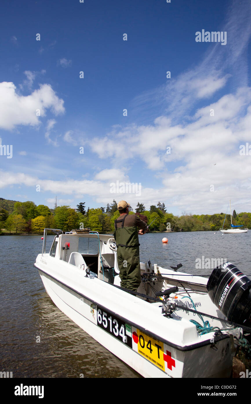 Fisherman casting with rod & line on Lake Windermere from a boat on a ...