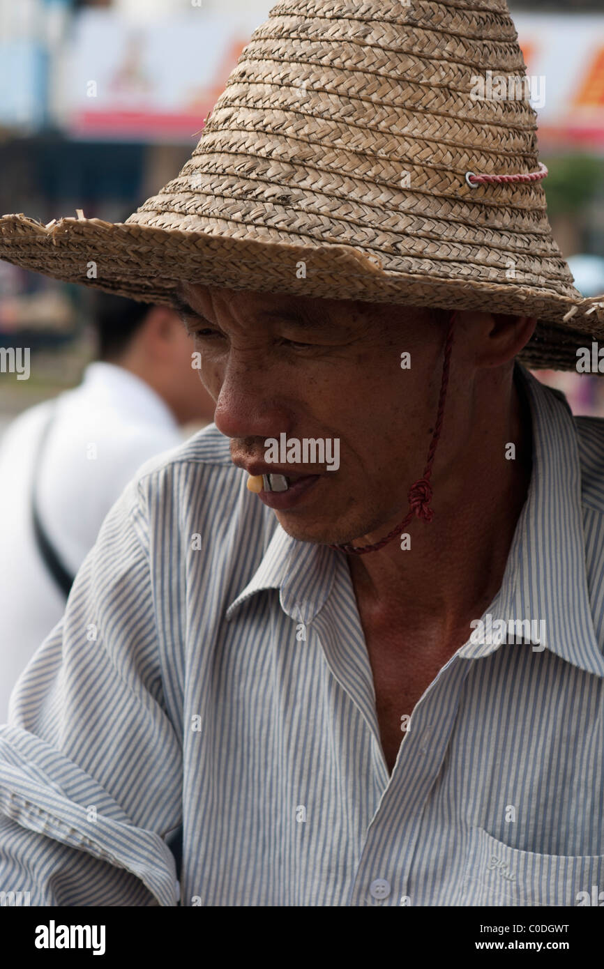 Portrait of a Chinese man in a hat with a very bad, sticking out teeth ...