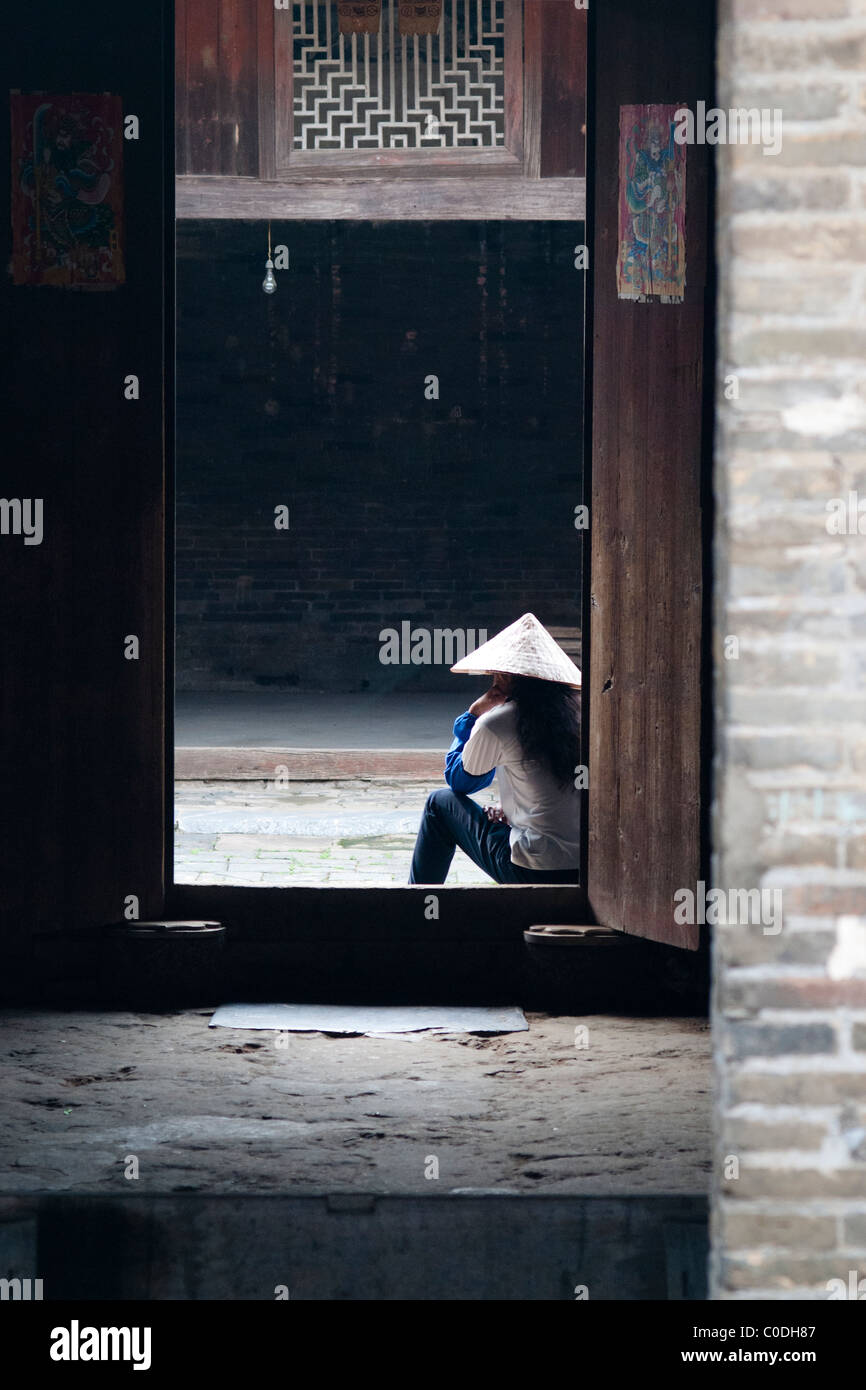 woman sitting on threshold of a traditional Chinese house Stock Photo ...