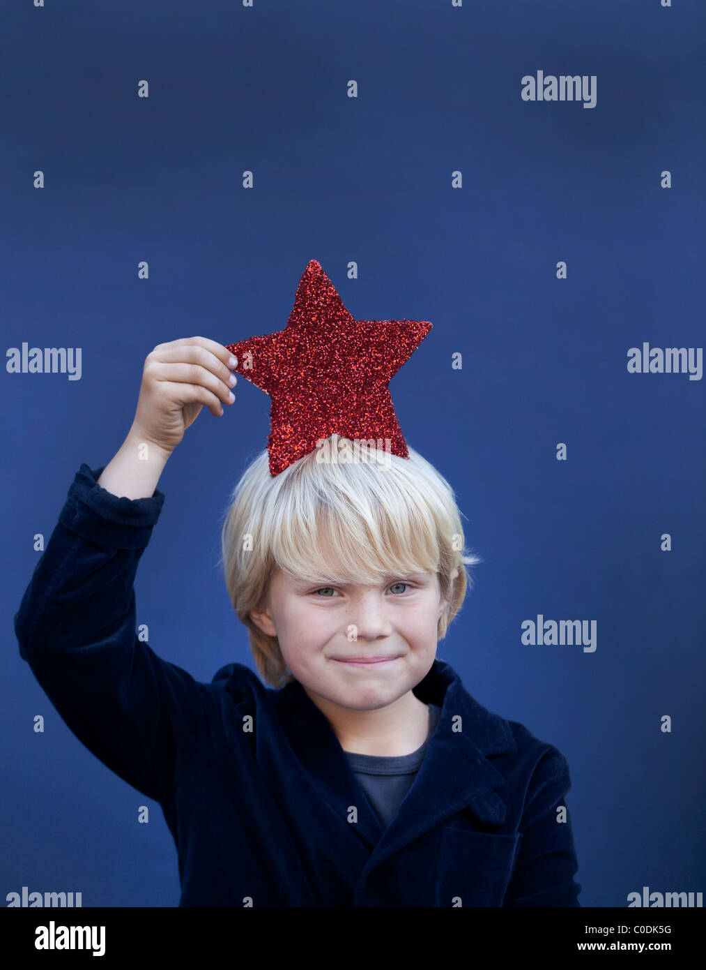 Little boy holding red star on his head Stock Photo - Alamy