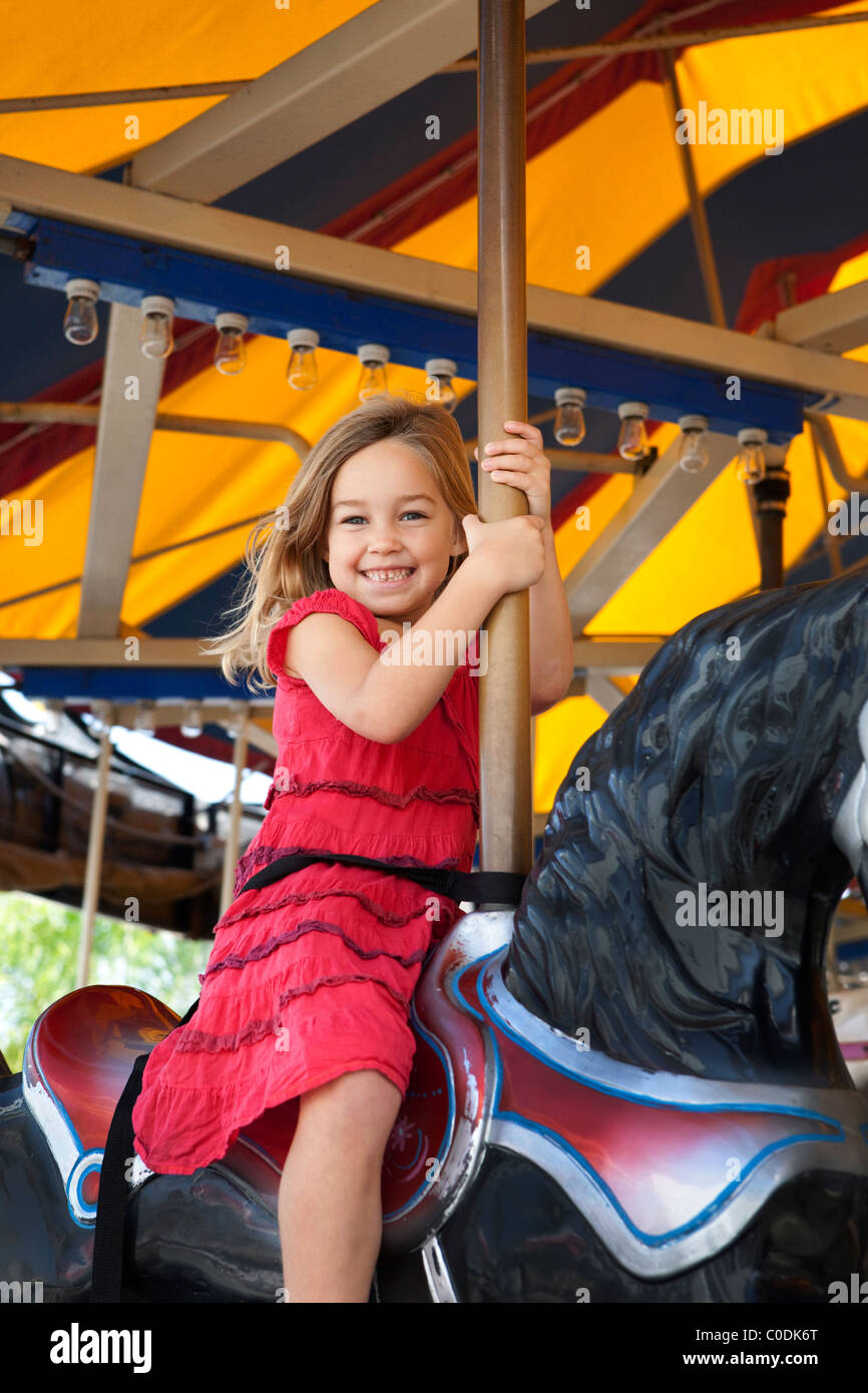 Little girl riding on the carousel Stock Photo - Alamy