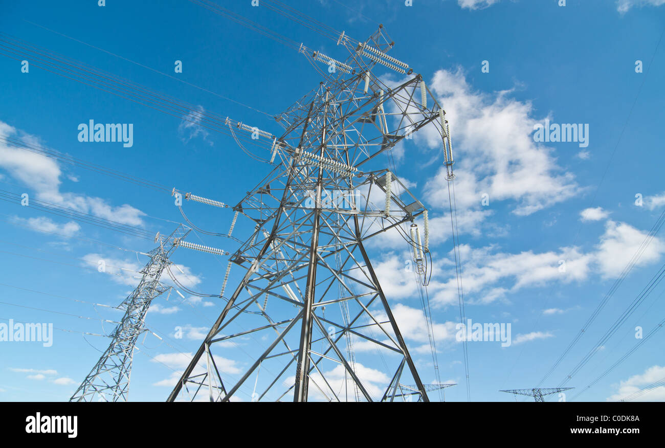 Three electrical transmission towers carrying high voltage lines Stock ...
