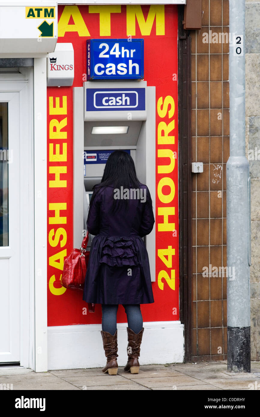 woman using a 24 hour atm machine Stock Photo - Alamy