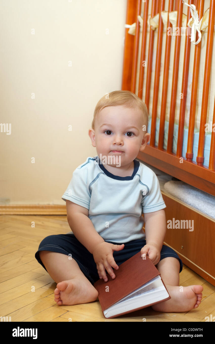 Little boy is reading book near his bed Stock Photo - Alamy