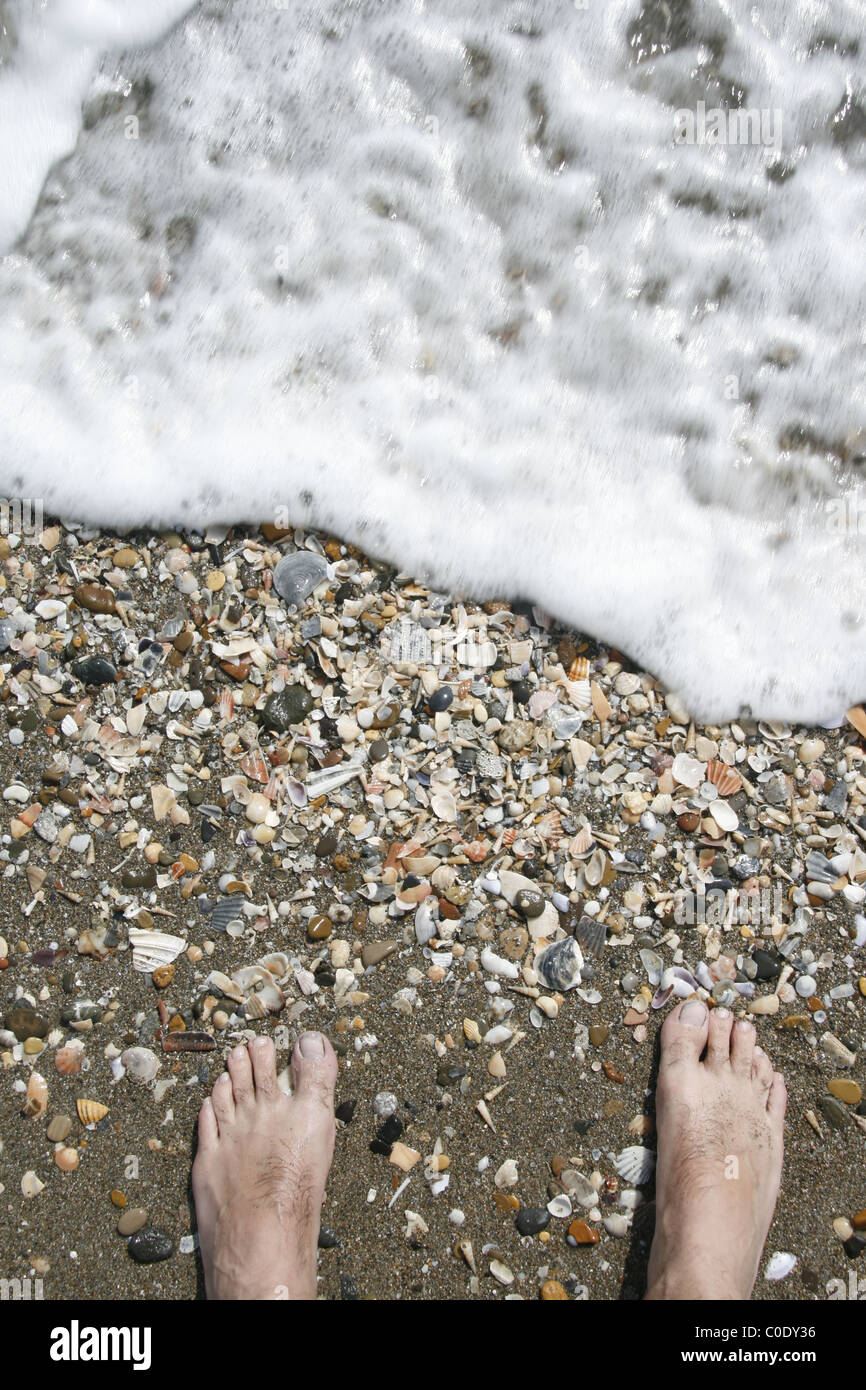 man standing on beach with wave Stock Photo - Alamy