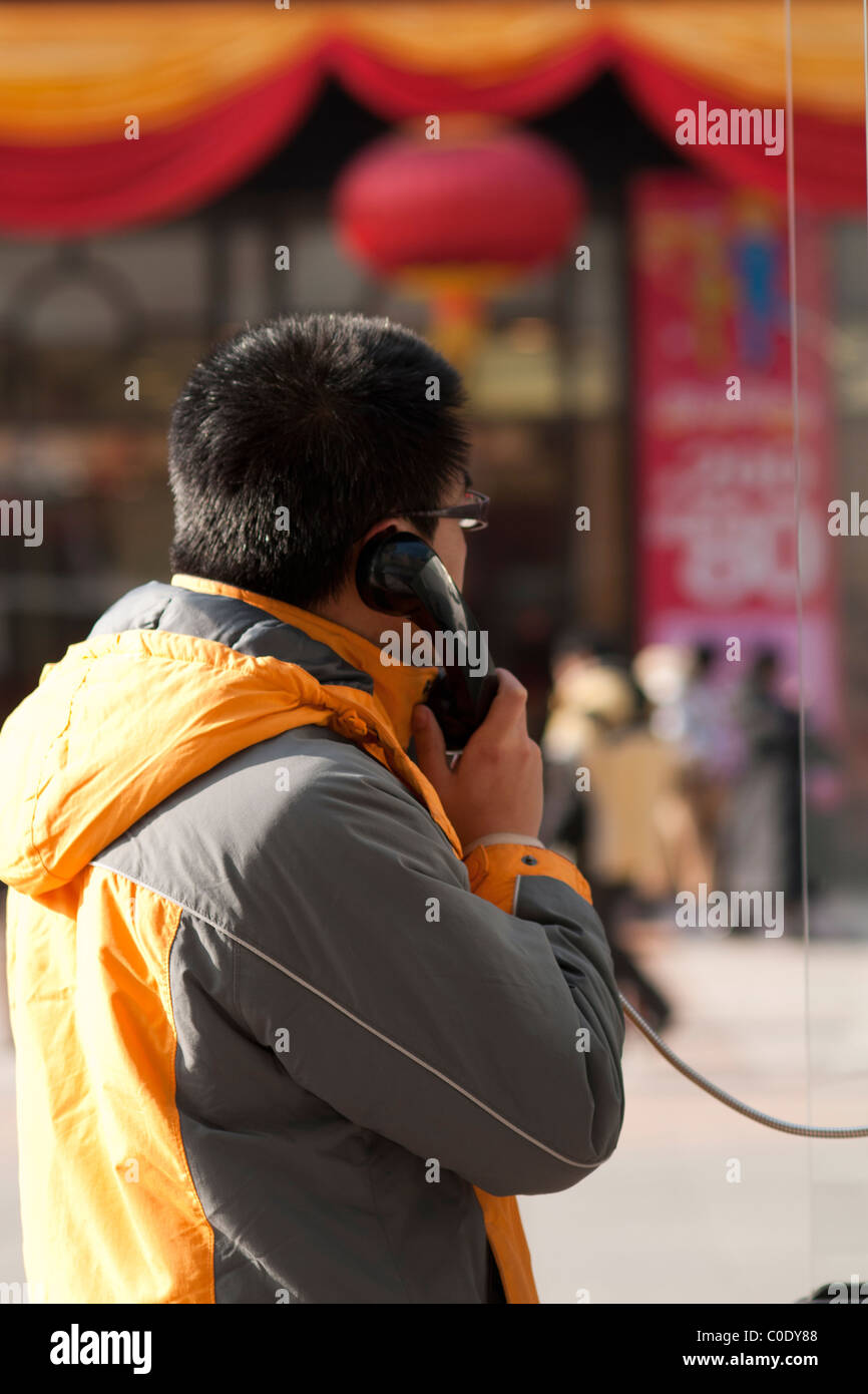 Chinese man talking on a phone box telephone, Beijing, CHina Stock ...
