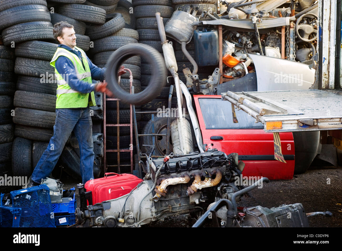 man in scrapyard throwing used tyres into the back of a truck Stock ...