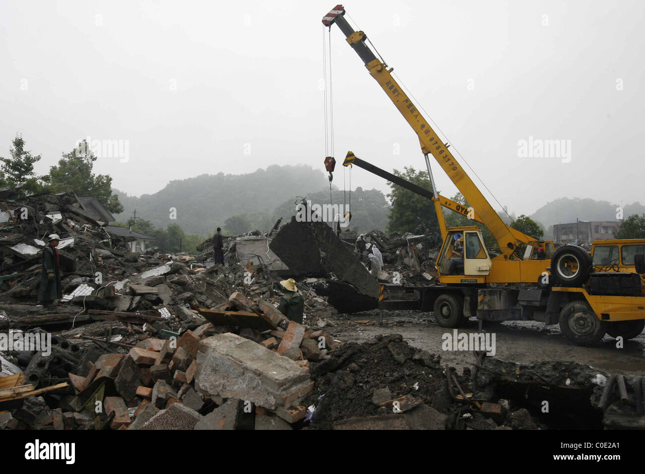 A crane lifts debris from a building after an earthquake in Dujiangyan ...