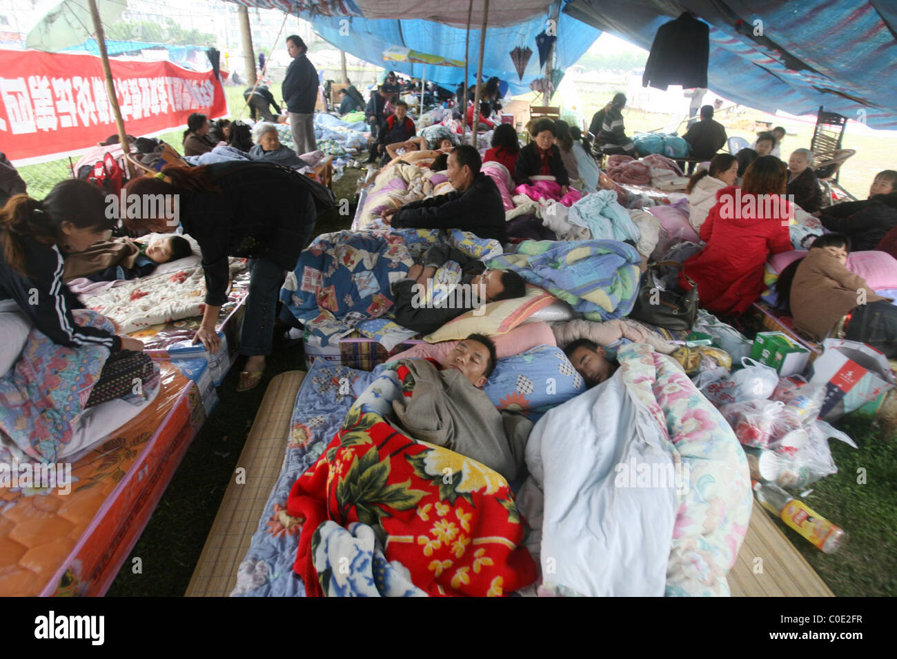 Earthquake victims wait for medical treatment in a makeshift hospital ...