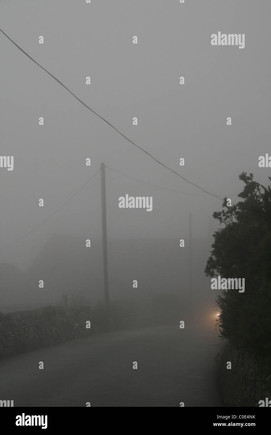 car in thick fog on country lane Stock Photo - Alamy