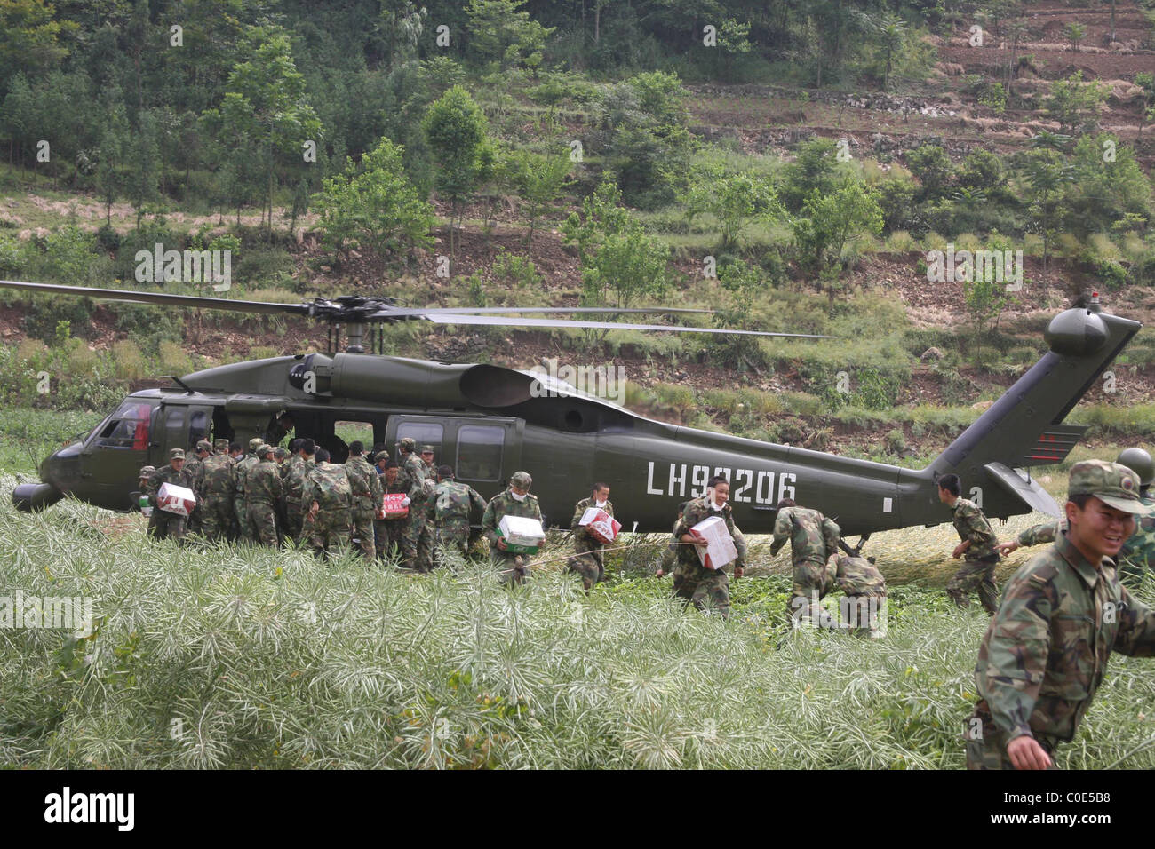PLA soldiers carry disaster-relief goods dropped by helicopter in ...