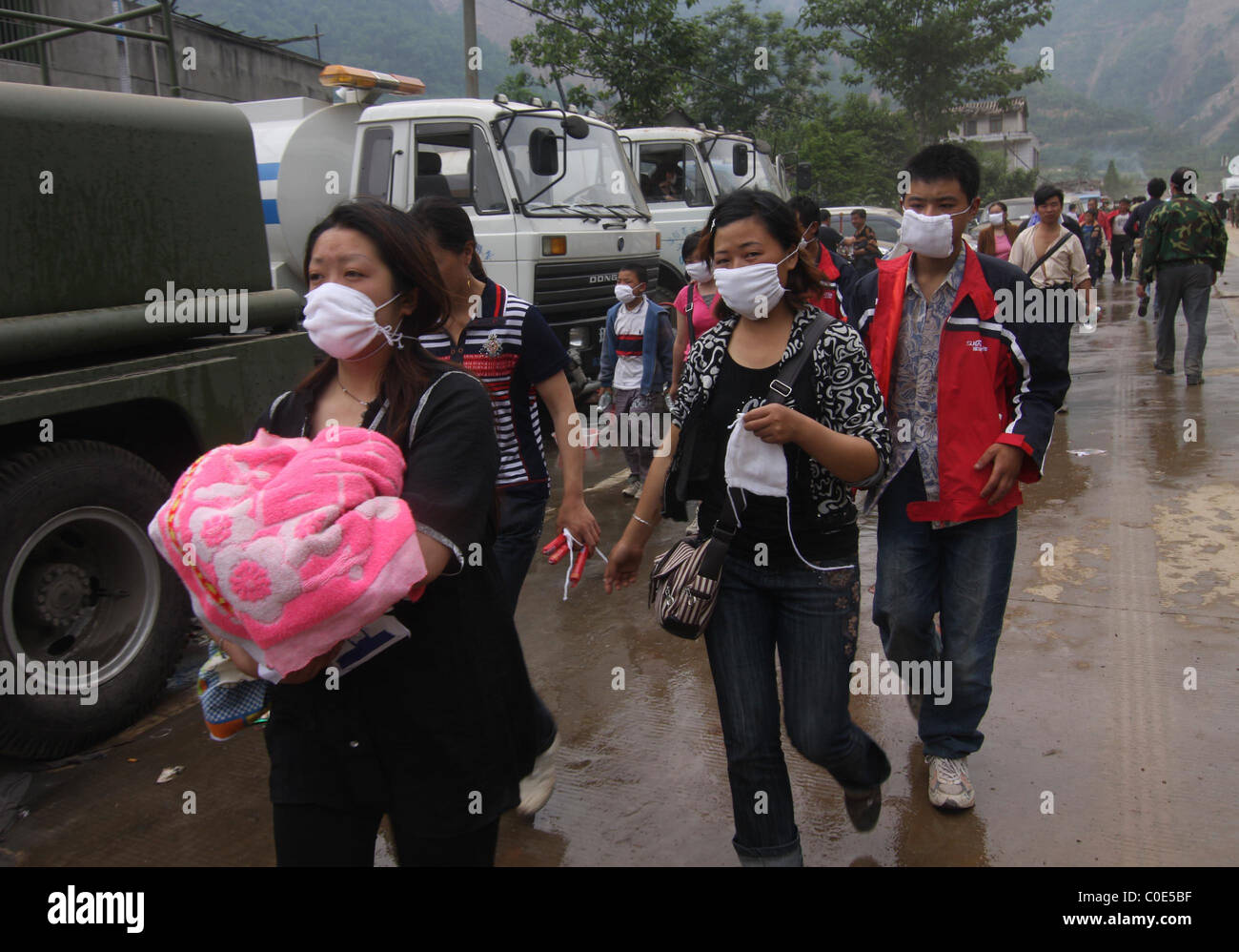 Local residents of Beichuan county wearing masks get out of their badly ...