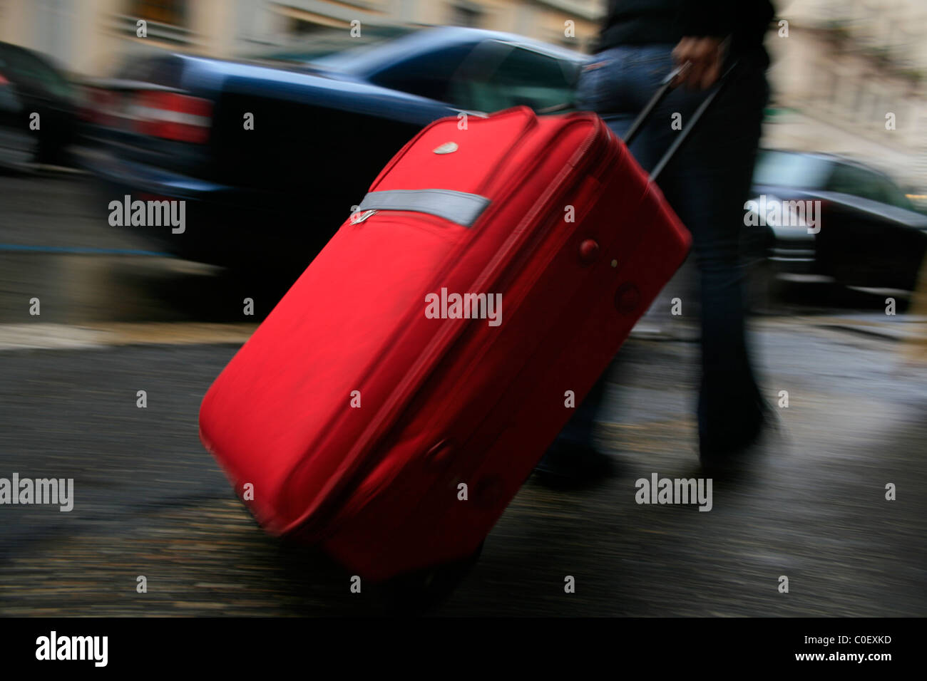 person pulling trolley luggage case in town Stock Photo - Alamy