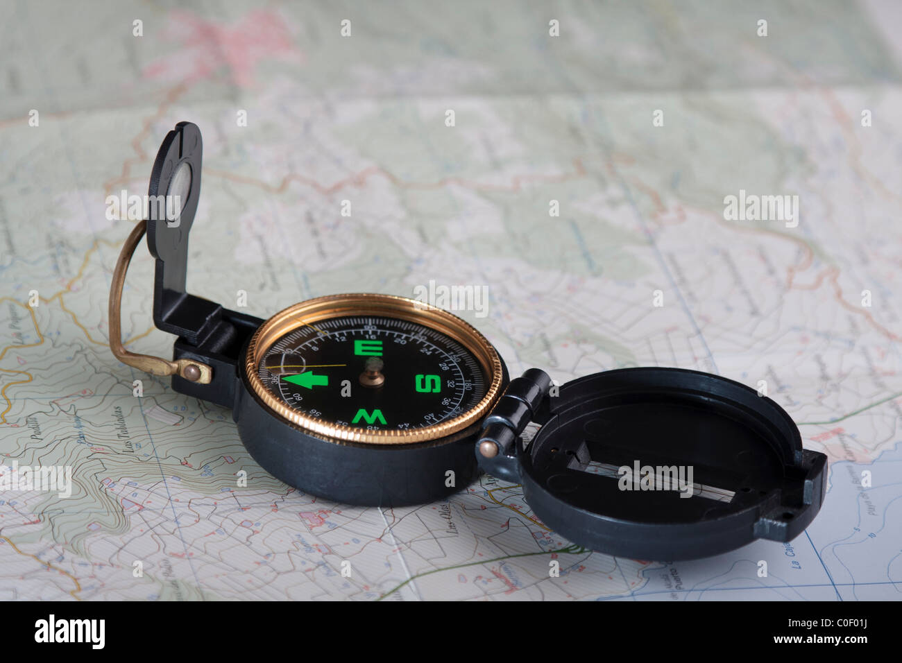 Modern compass open on a map Stock Photo - Alamy