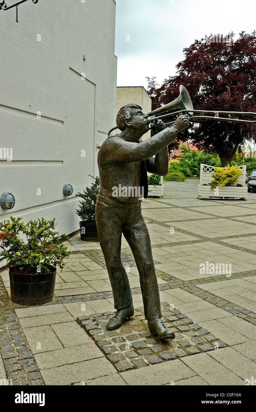 A bronze sculpture of a trombonist playing a trombone with a bent slide ...