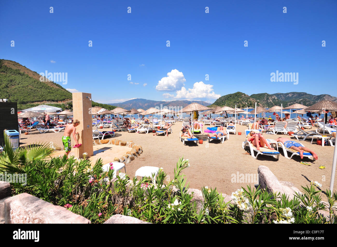 View of a sandy beach with people sunbathing, Icmeler, Turkey, Europe ...