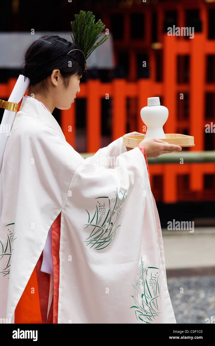A woman carrying offering in traditional ceremony at the Fushimi Inari ...