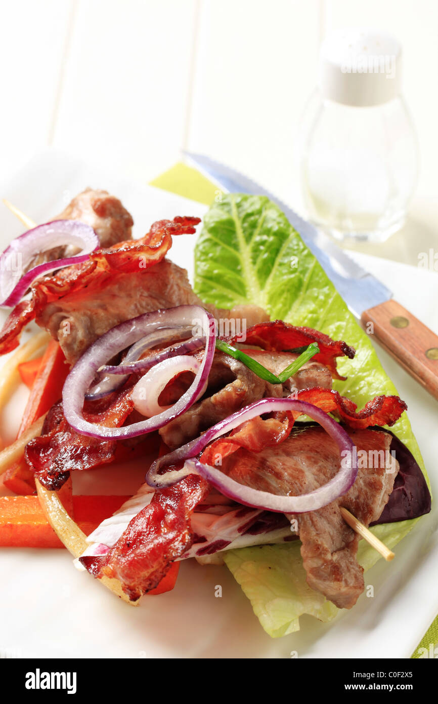 Shish kebab with crispy rashers of bacon and roasted vegetables Stock ...