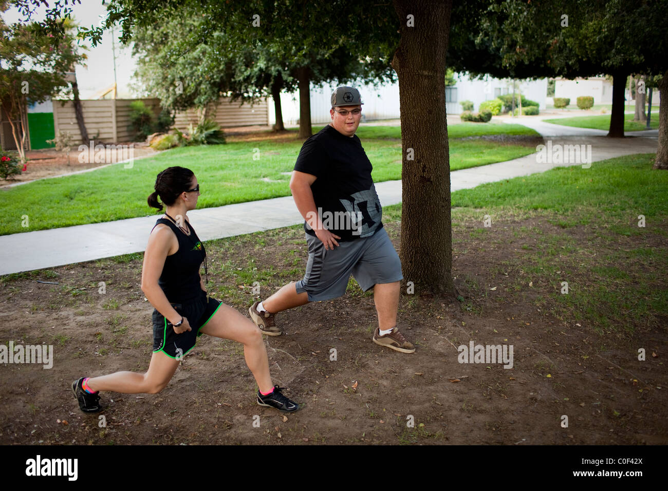 Reedley, California, United States. An obese teenage boy stretches his ...