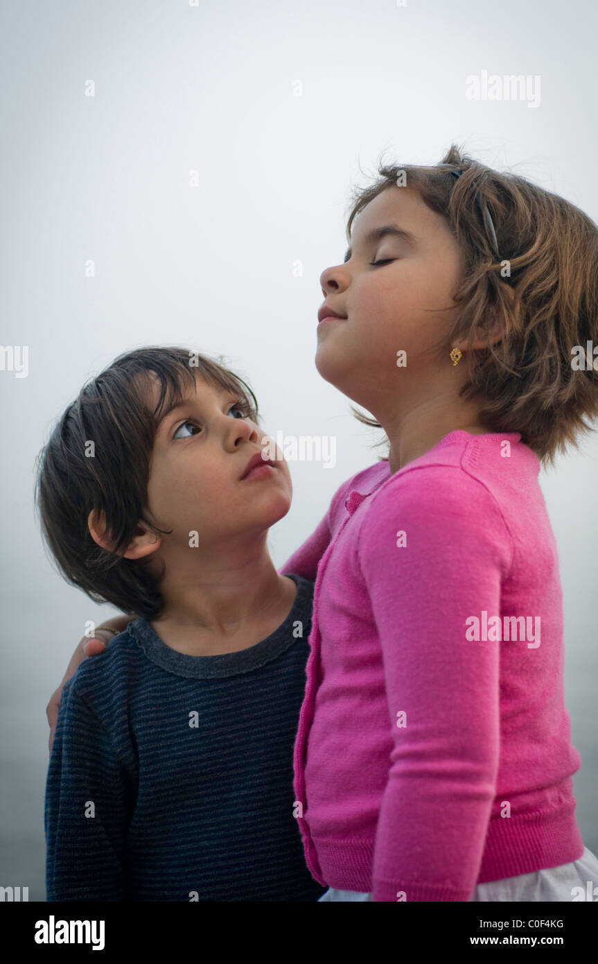 Little brother looking up at big sister Stock Photo - Alamy