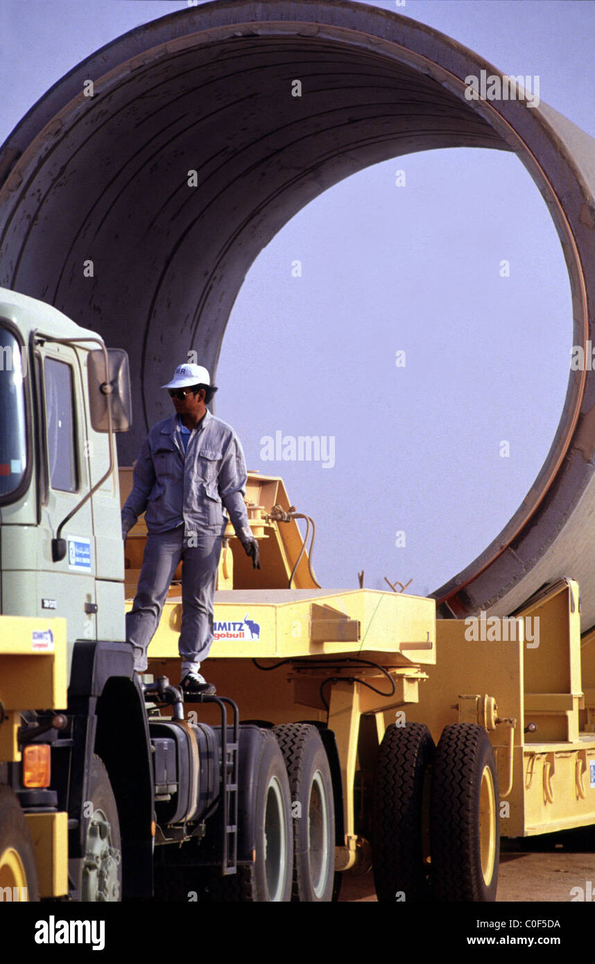 A MAN STANDS ATOP A TRUCK HAULING THE MASSIVE PIPES MADE FOR THE "MAN ...