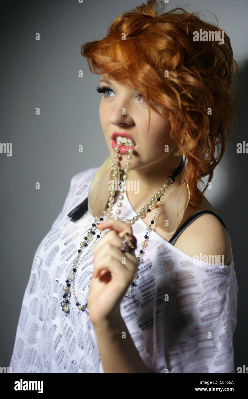 Teenage girl biting pearl necklace Stock Photo - Alamy