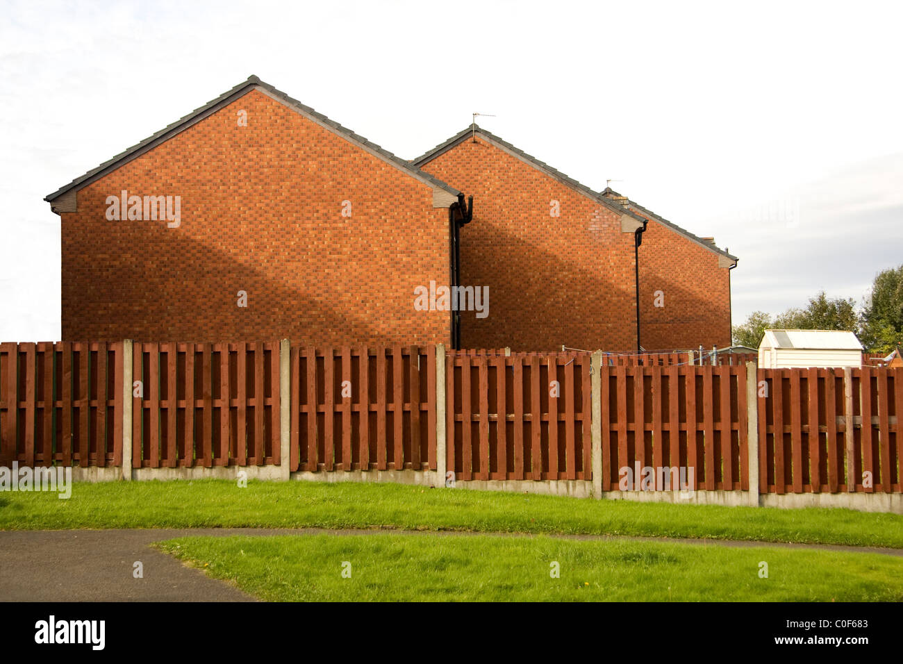 Three identical houses with wooden fence and green grass Stock Photo ...