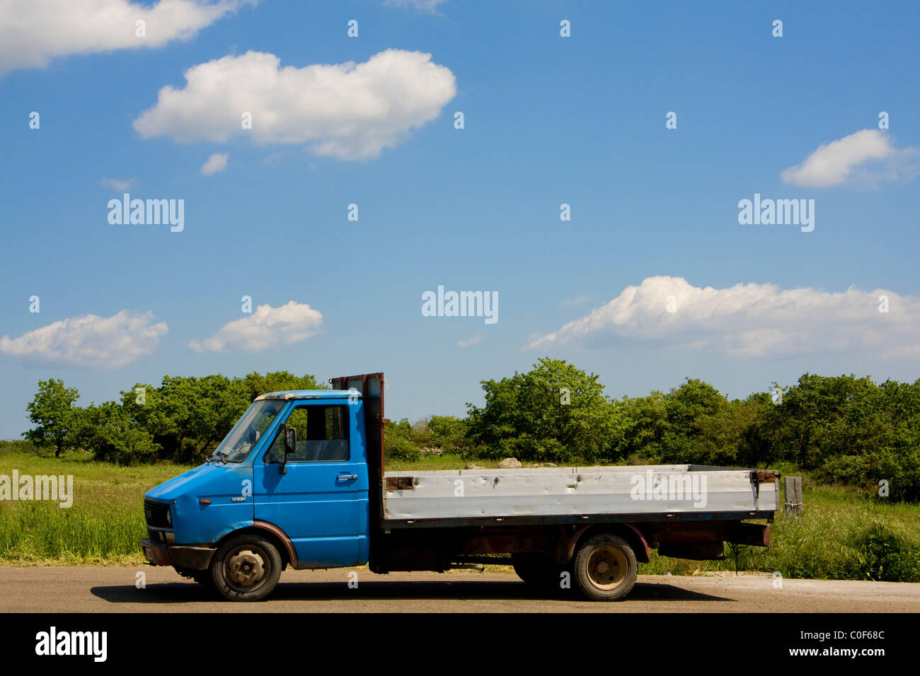 Blue lorry and blue sky with white clouds and green vegetation Stock ...