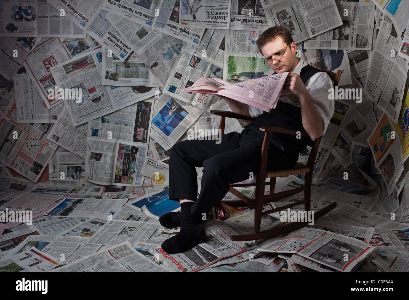 Man reading a newspaper in a room full of hanging newspapers Stock ...