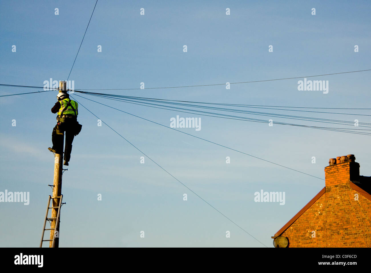Man repairing the light post on a sunny day with blue sky Stock Photo ...