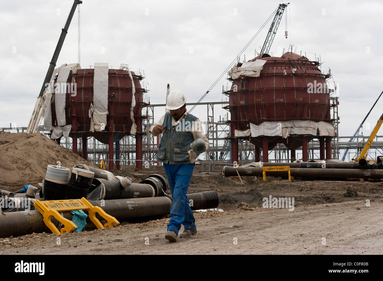 Workmen at work at the Sakenergy liquefied natural gas plant and oil ...
