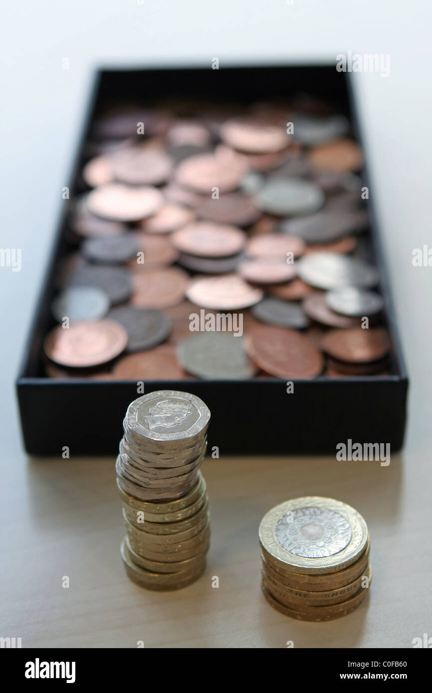 Stacks of sterling £2 and 20p coins with a bag of mixed denomination ...