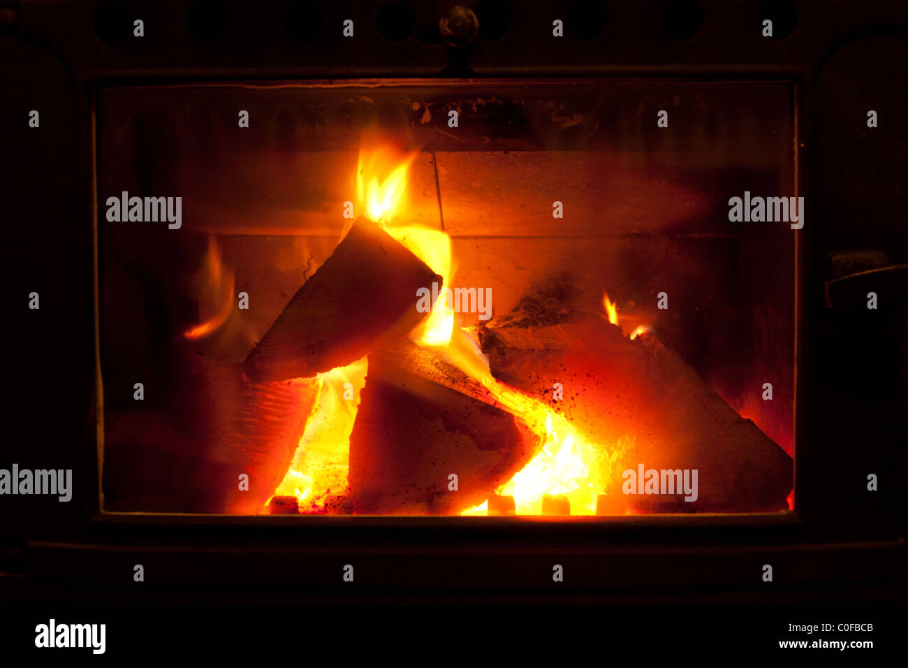 Logs on fire in wood burning stove Stock Photo - Alamy