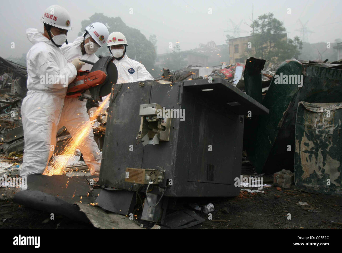 Rescuers dismantle a safe dug out from ruins of a credit co-operative ...