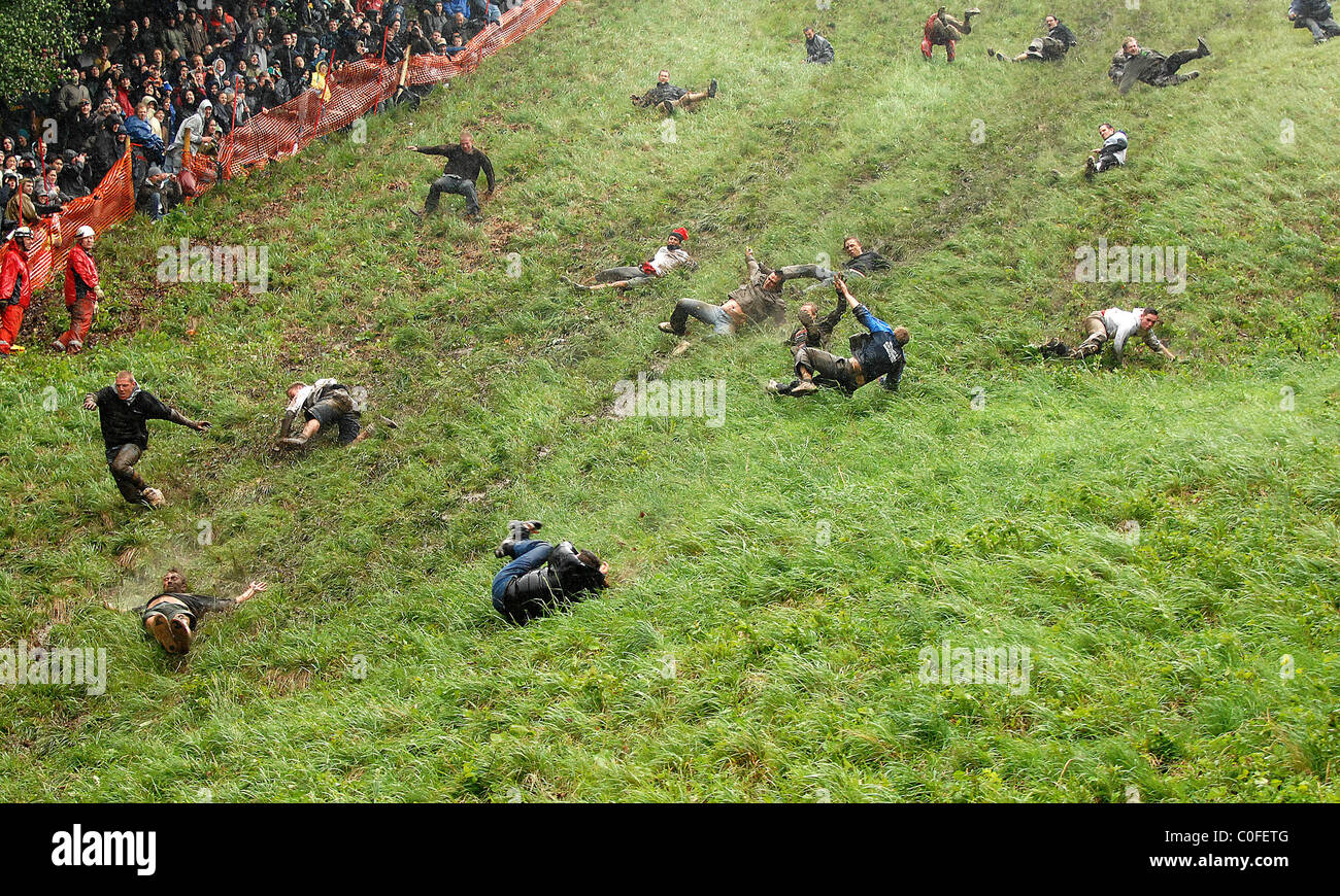 Competitors chase a Double Gloucester Cheese down the steep gradient of ...