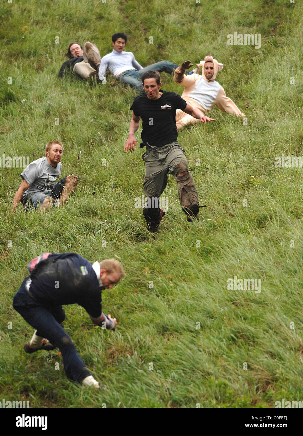 Competitors chase a Double Gloucester Cheese down the steep gradient of ...